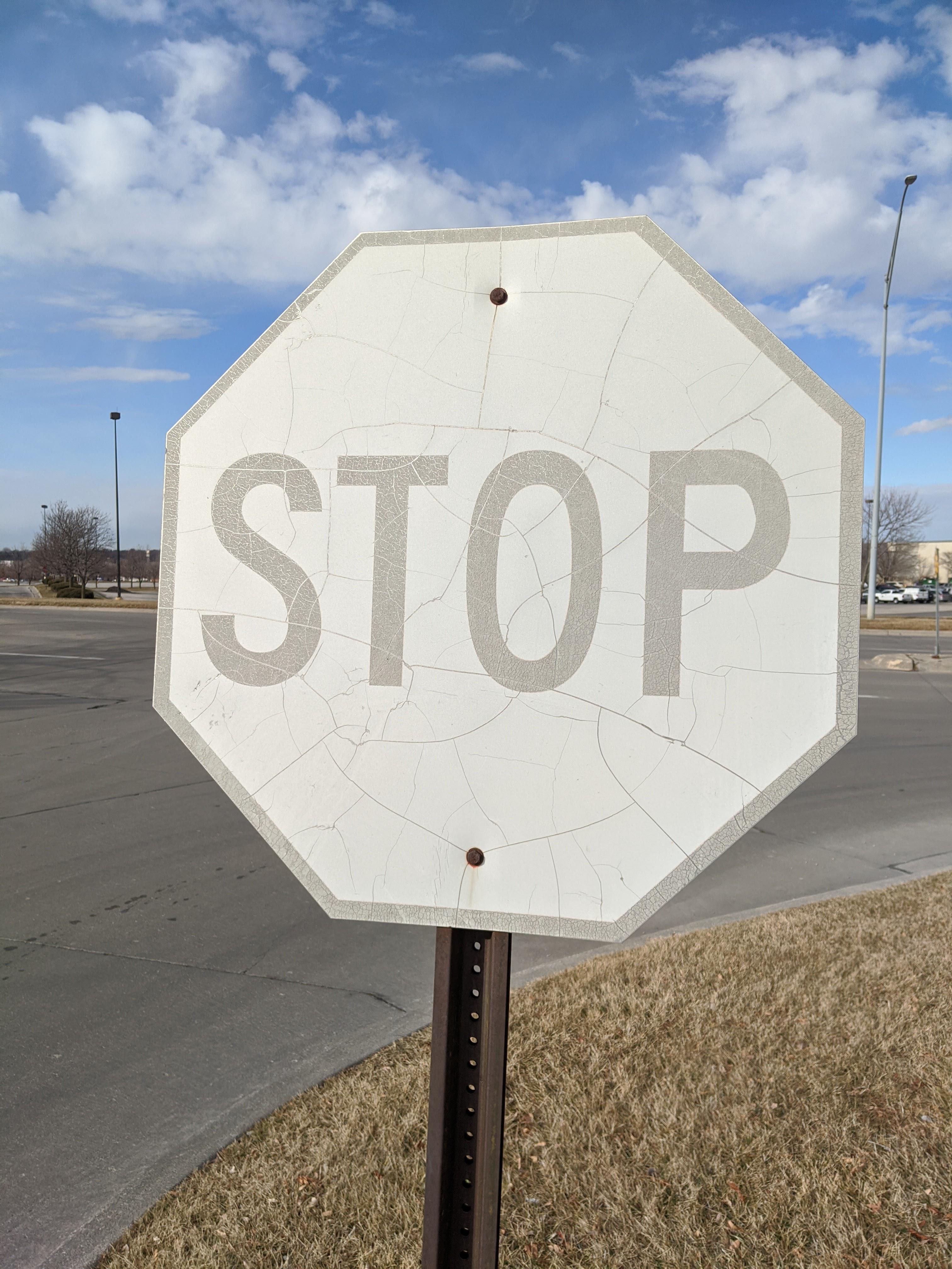 This stop sign has been bleached by the sun for so long that it's now ...