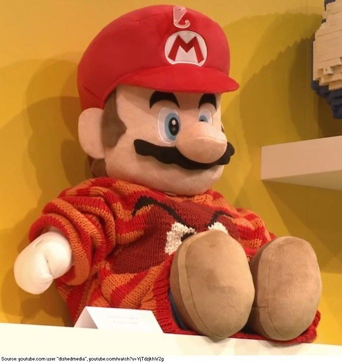 Mario toy dressed in a custom-knitted Goomba sweater, used as a ...